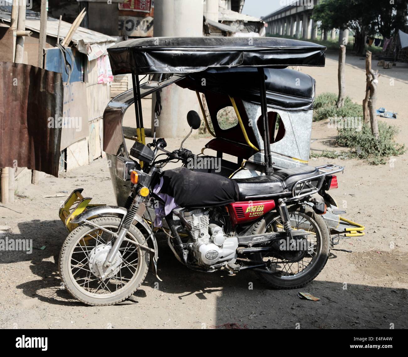 It's a photo of a sidecar motorcycle parked on a earth rood in the ...
