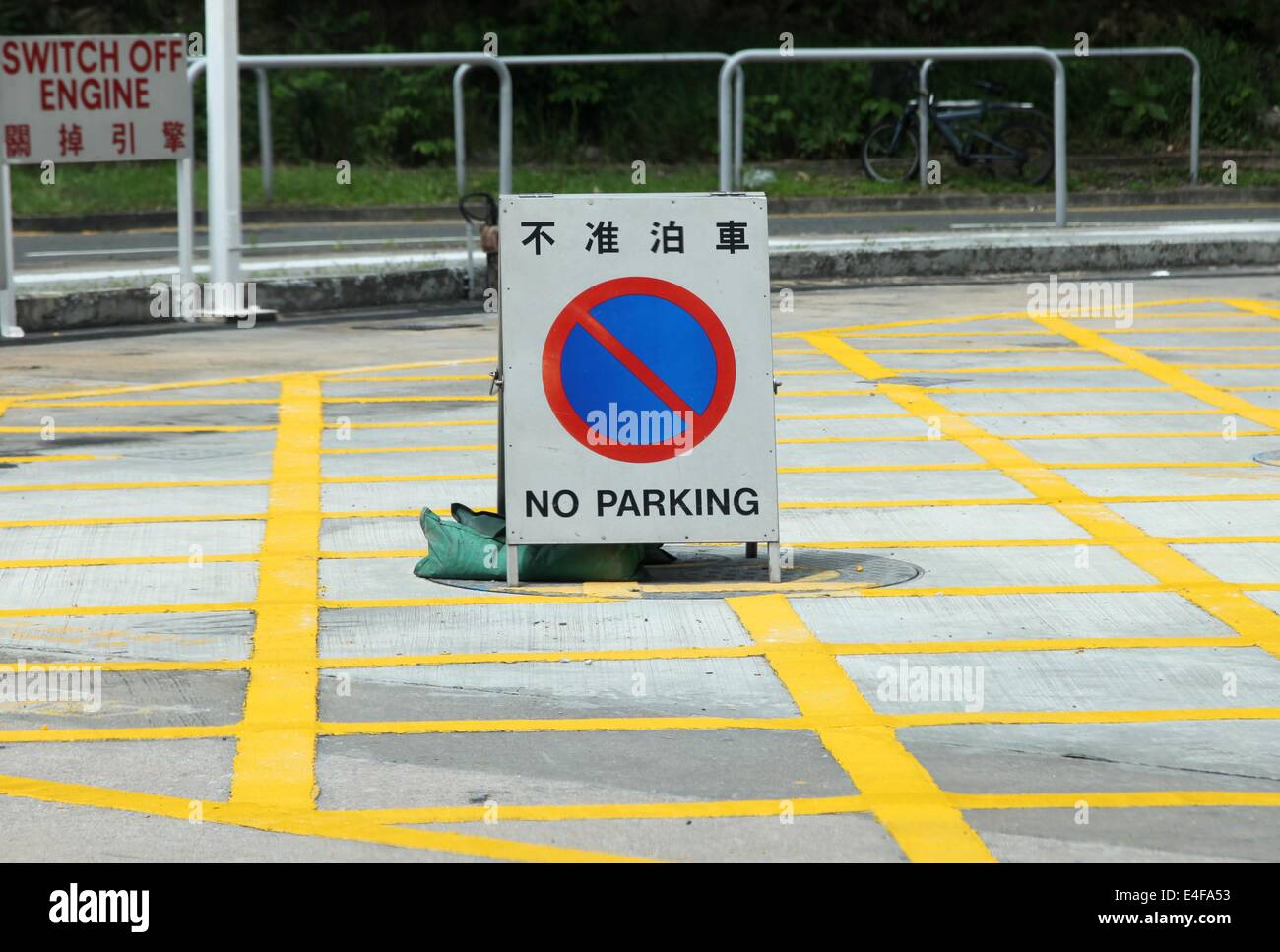 It's a photo of a road sign that says NO PARKINg in English and Chinese ...