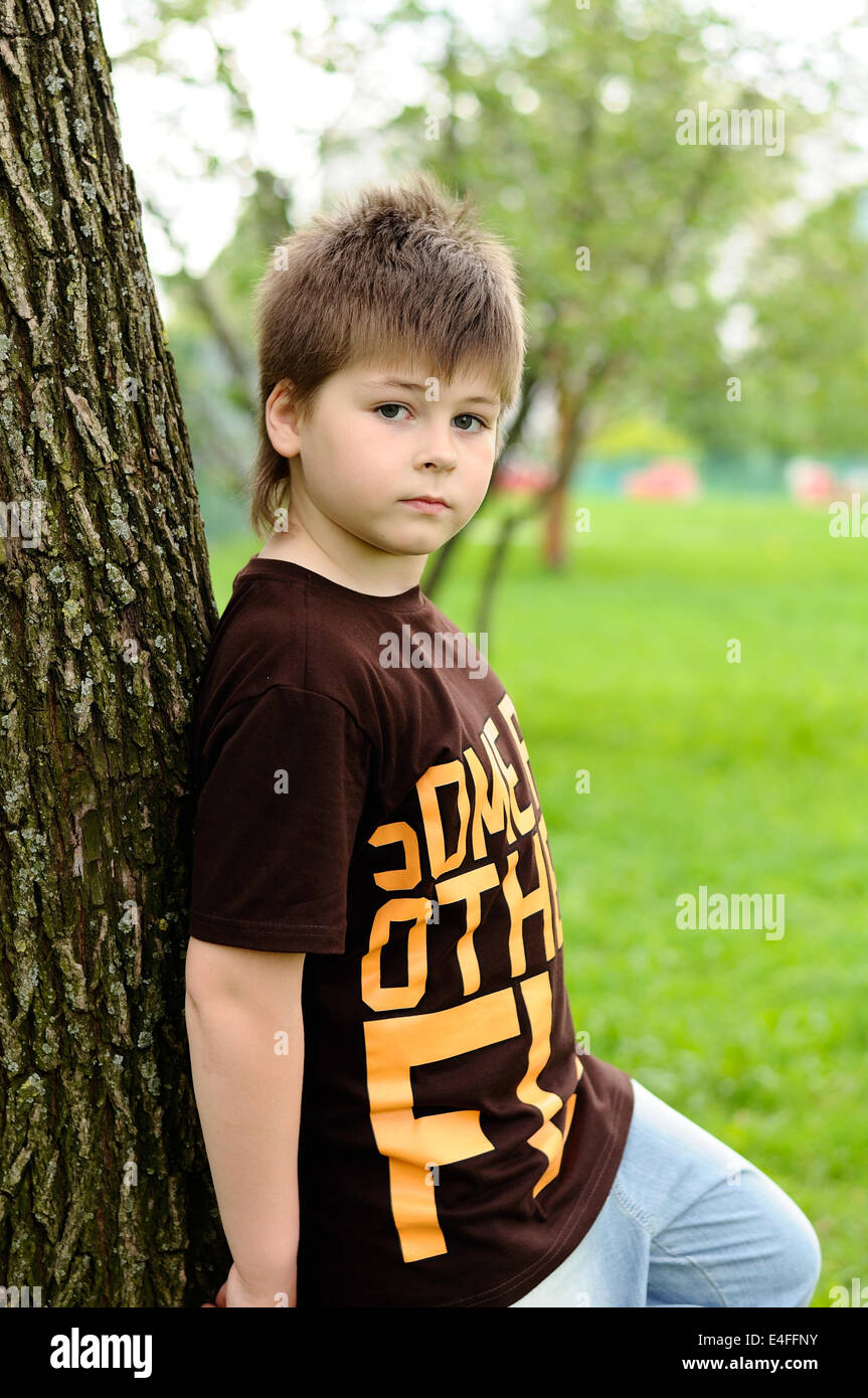 The boy near a tree in the park Stock Photo - Alamy