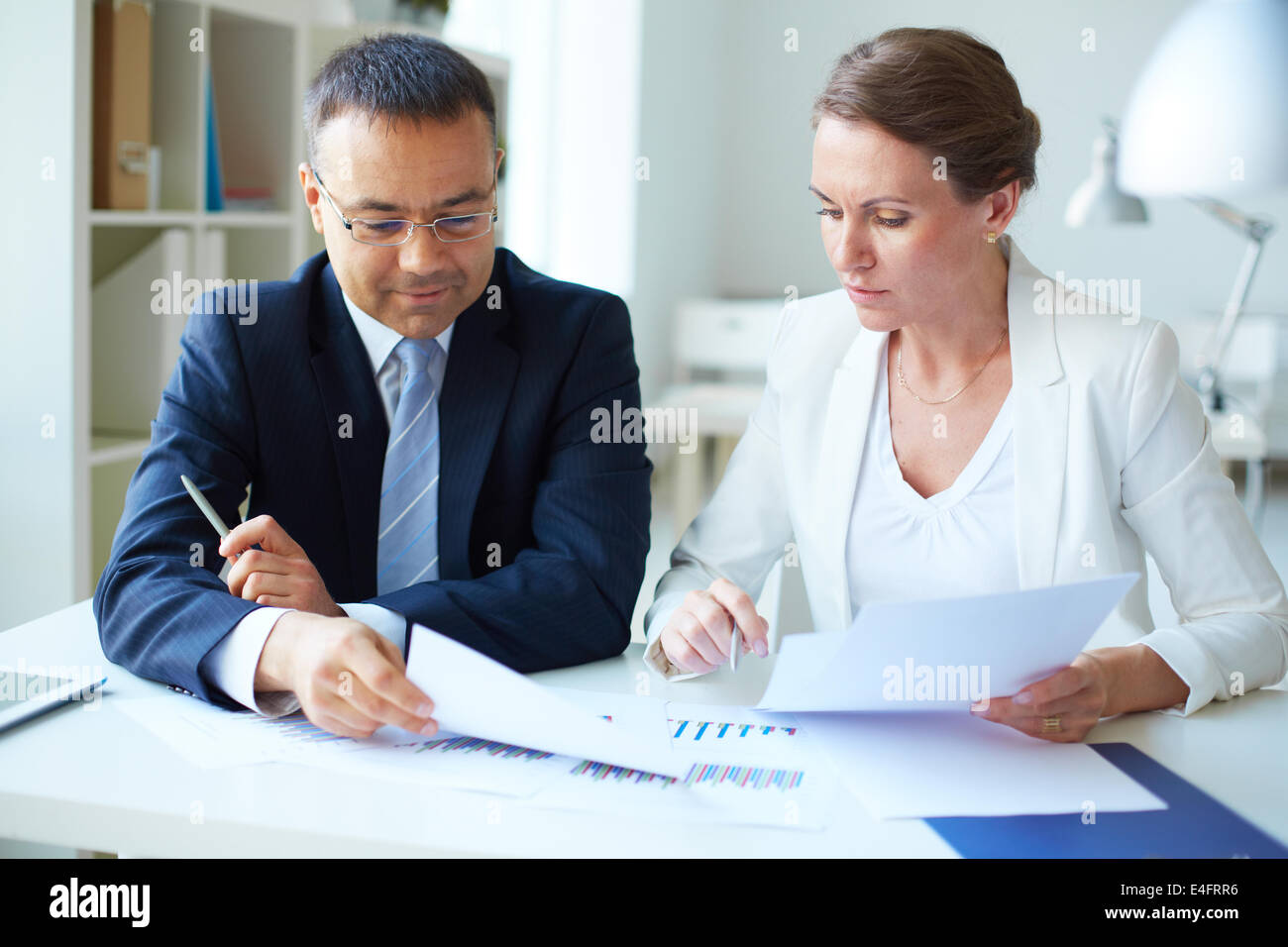 Two mature business partners discussing documents in office Stock Photo ...