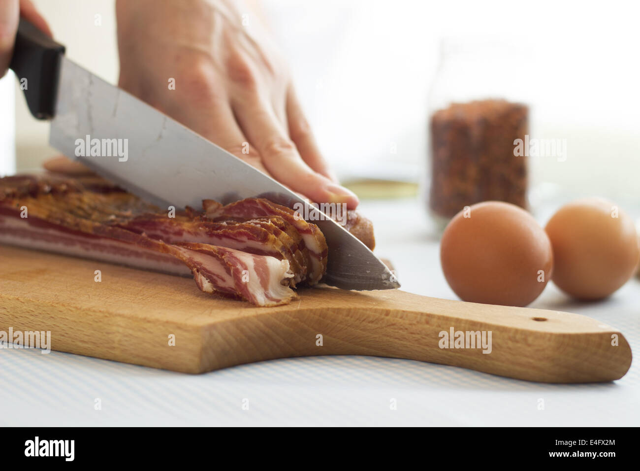 Chef cutting bacon into strips, close up Stock Photo - Alamy