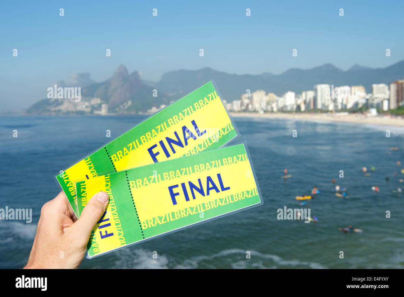 Hand holding pair of final Brazil tickets in front of sea view Ipanema ...
