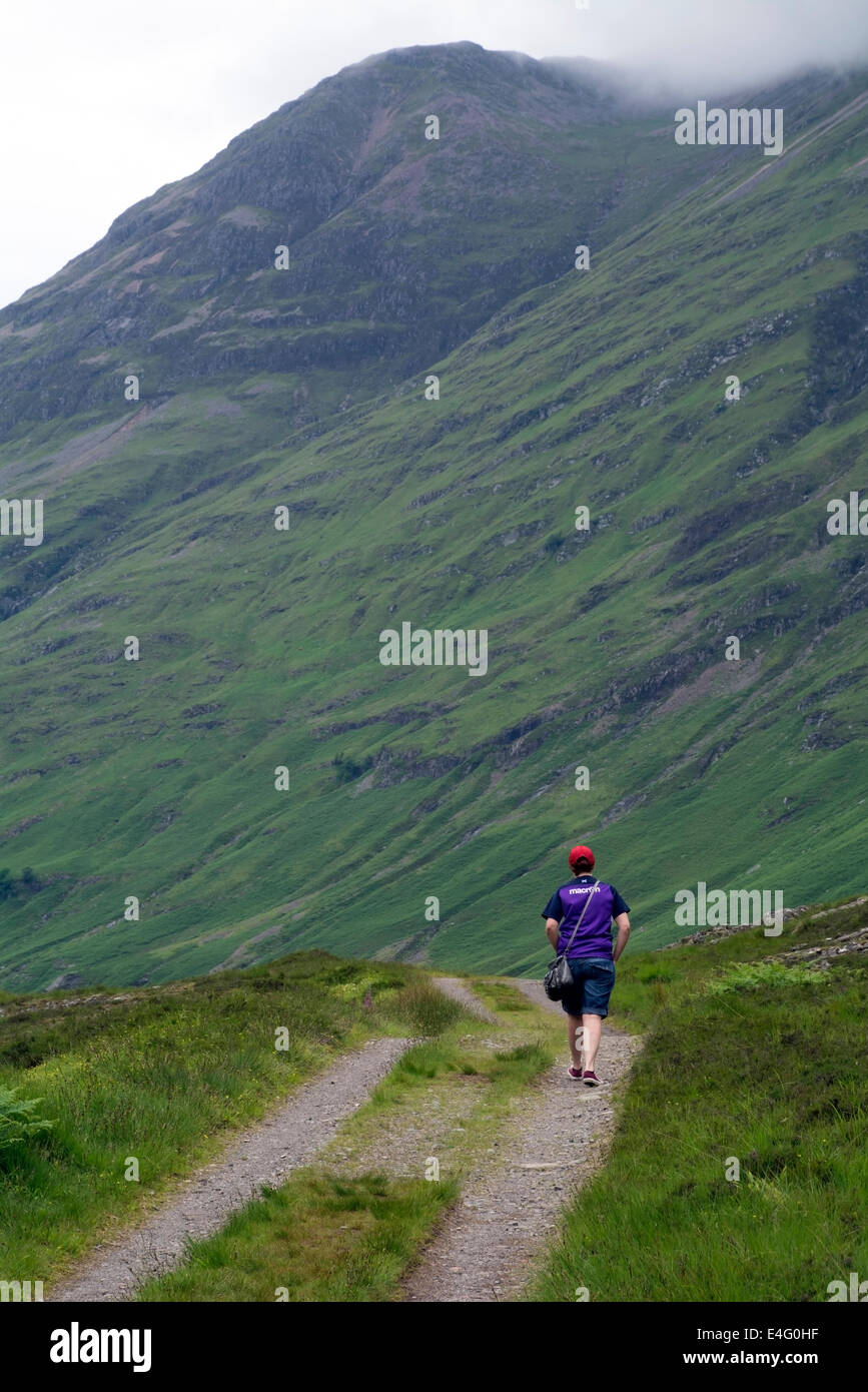 A young woman walking along a track in Glencoe, Scotland Stock Photo ...