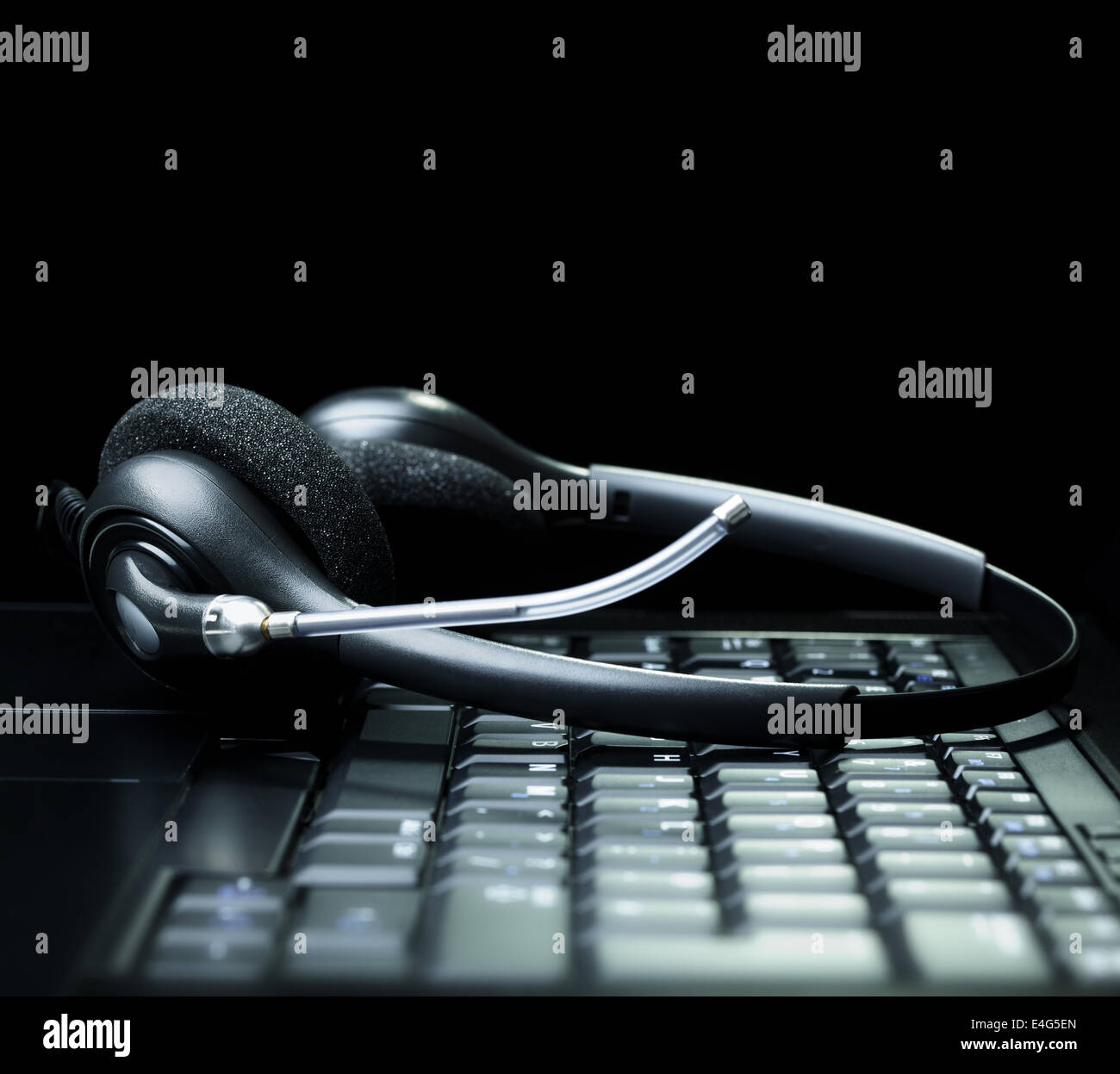 Headset on a laptop computer keyboard Stock Photo - Alamy