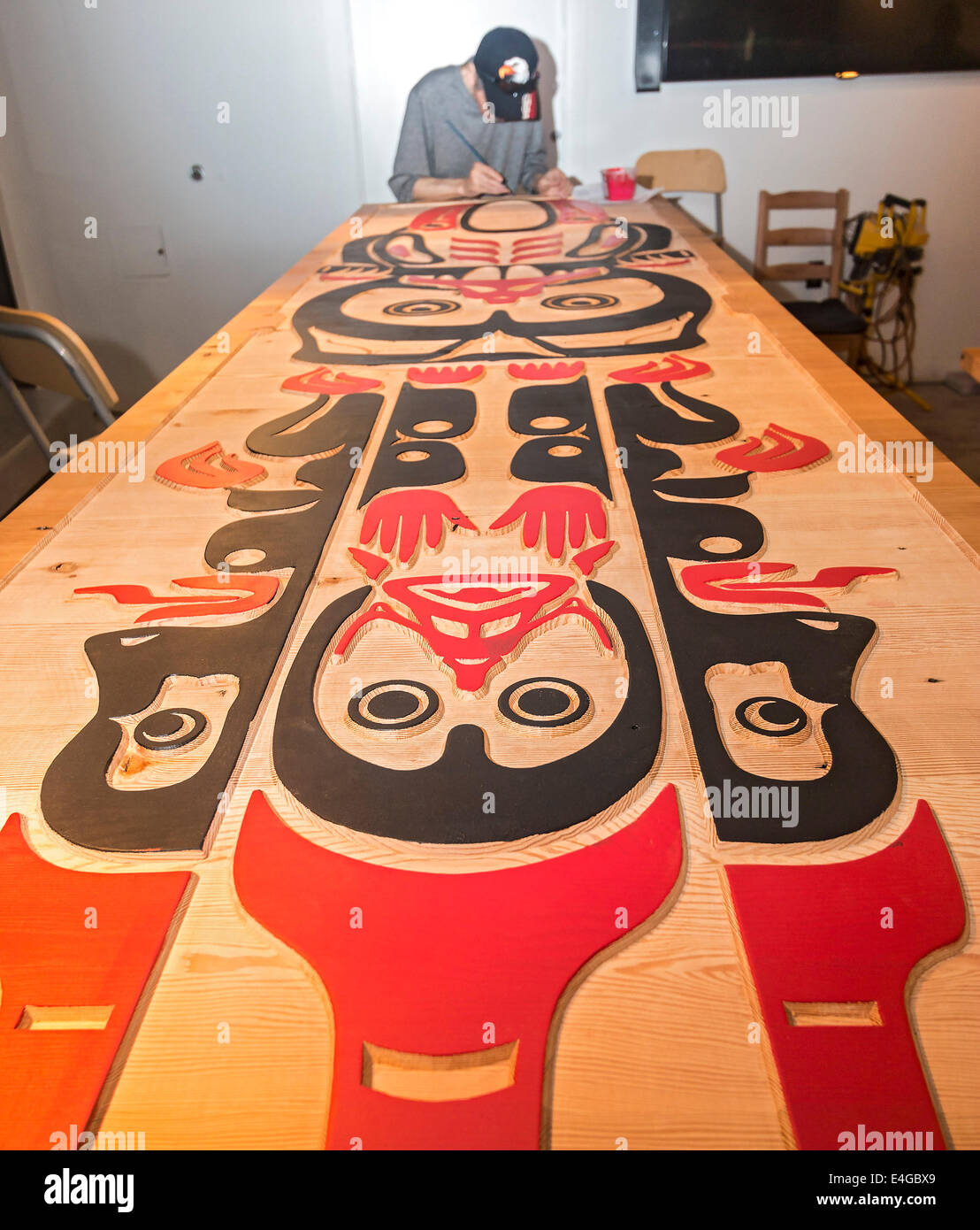 Haida artist Eric Parnell paints a boardroom table that he carved out ...