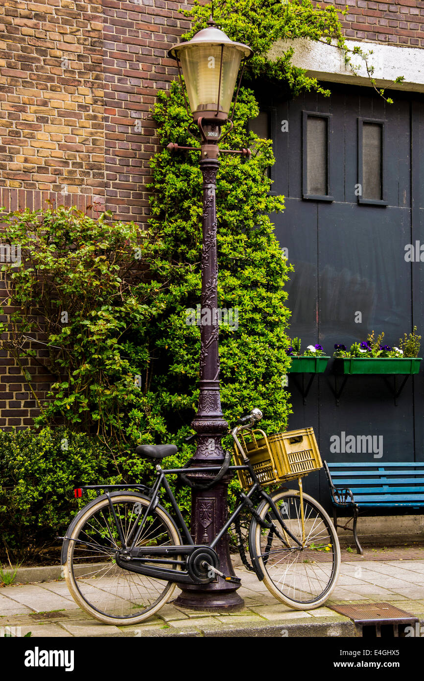 Bicycle tied on a light pole in Amsterdam Stock Photo - Alamy