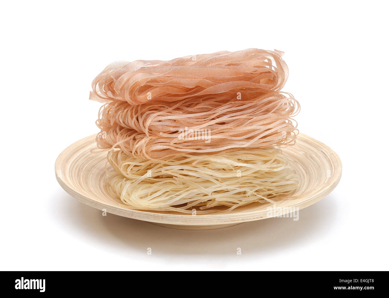 Dried brown rice noodles in the wooden tray isolated on white ...