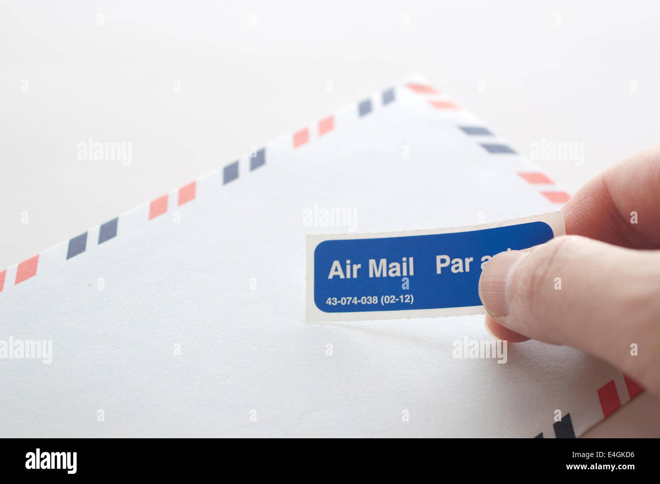 Putting air mail tag on envelope Stock Photo - Alamy
