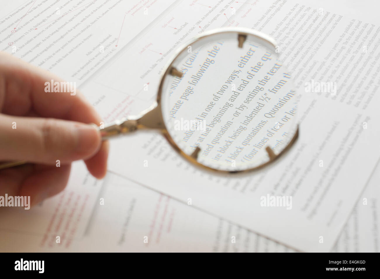 Close up hand holding magnifying glass to read document Stock Photo - Alamy
