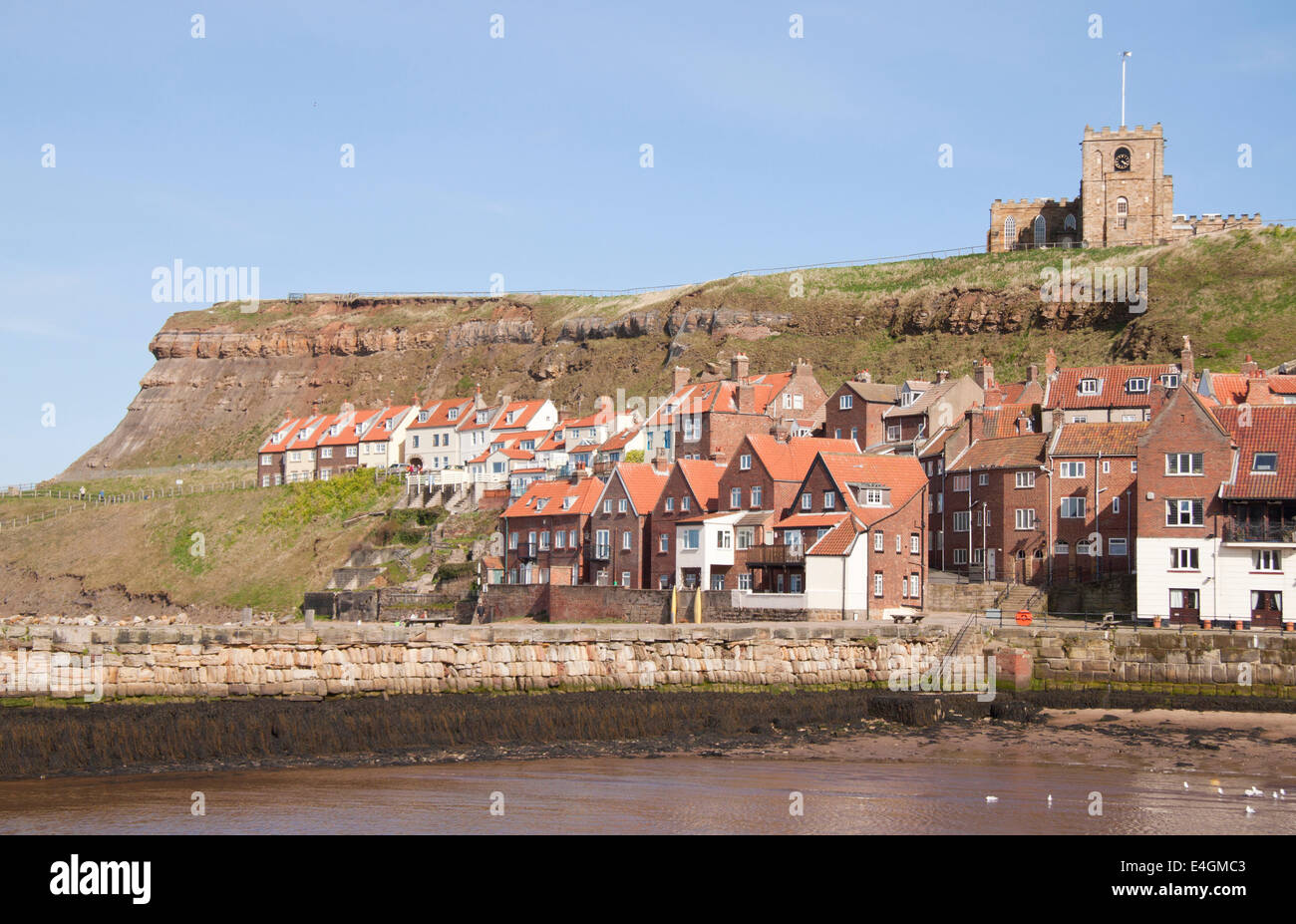 View of Whitby harbour showing the cliffs above the town and the church ...