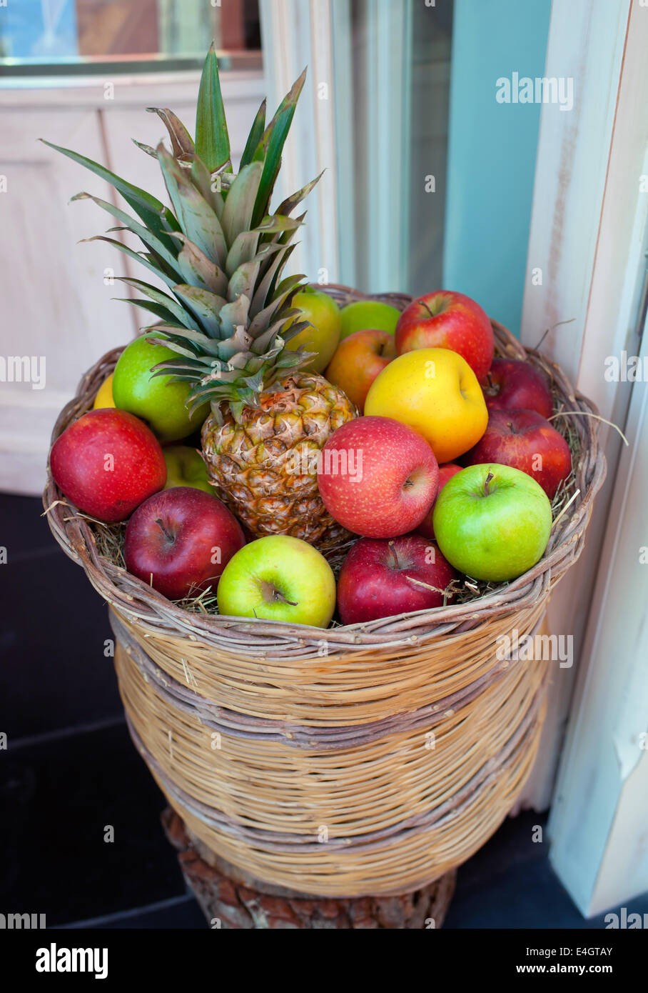 Basket of fruit, pineapple and apples Stock Photo - Alamy
