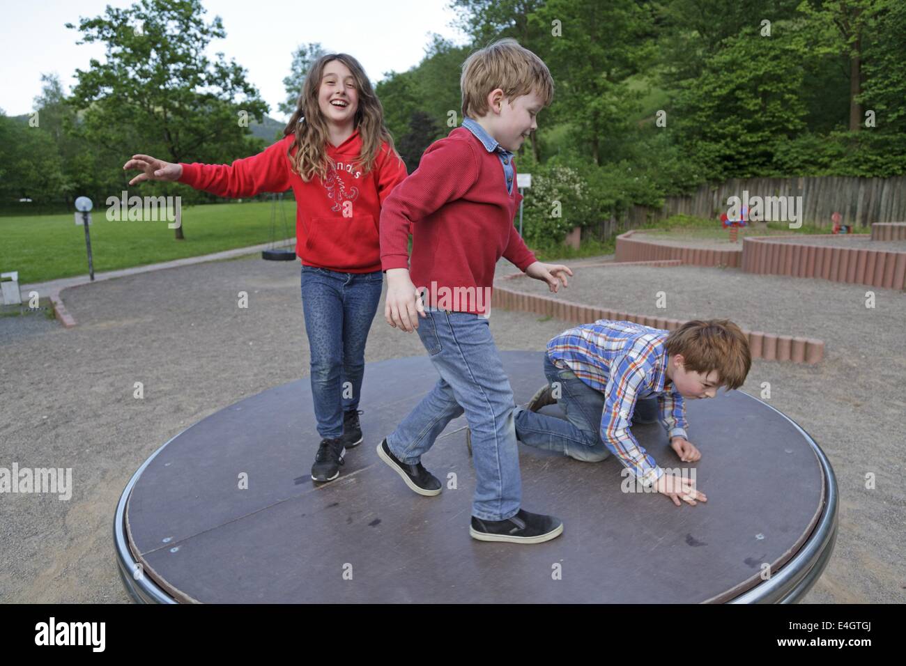 children on a playground roundabout Stock Photo - Alamy