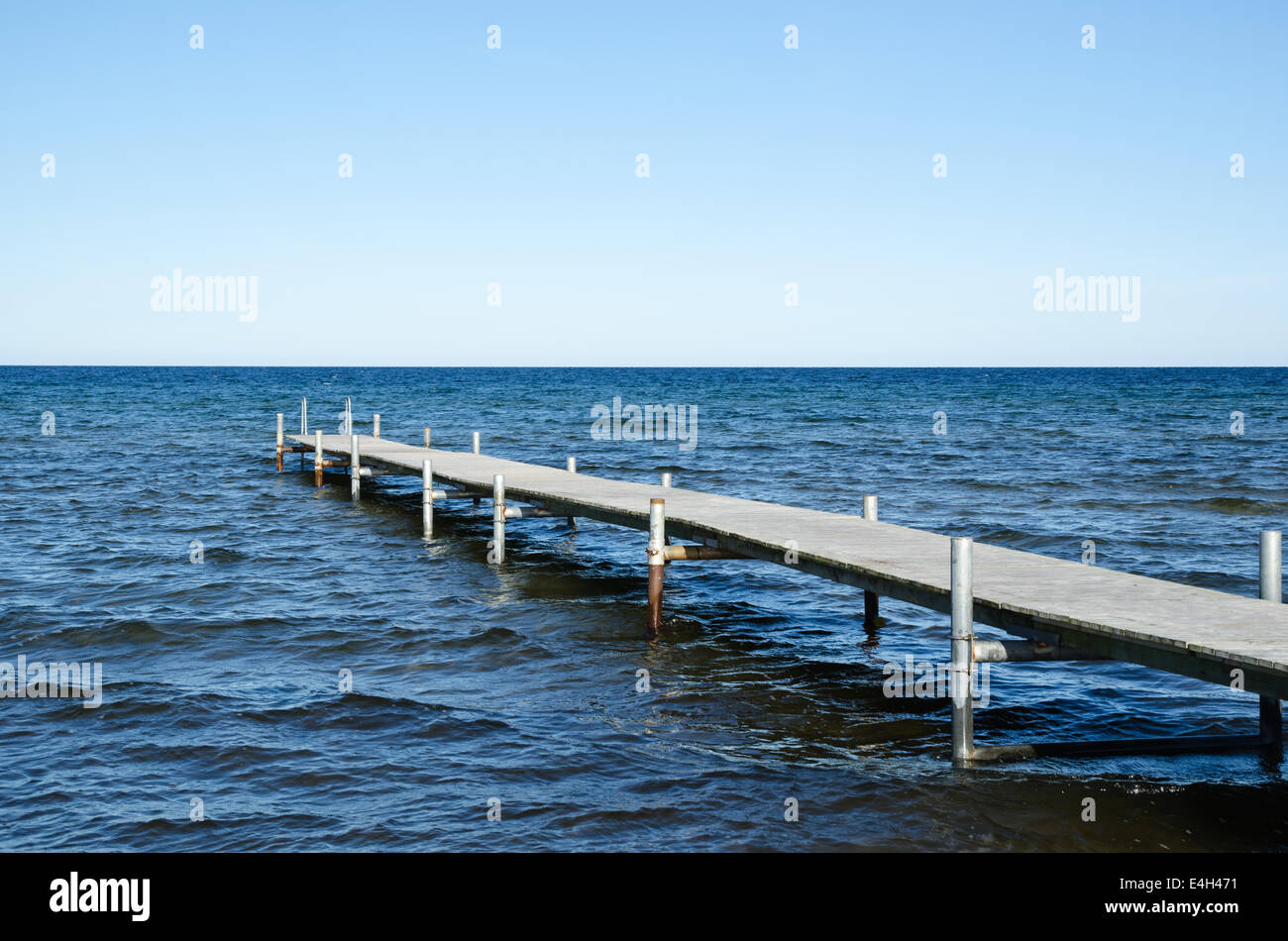 Wooden bath pier at blue water by the coast of the swedish island Oland ...