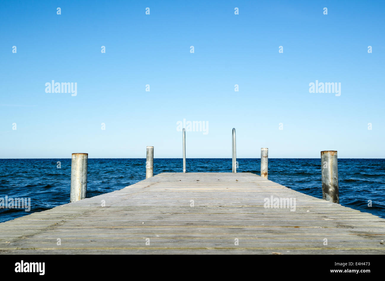 Low angle image of a wooden bath pier in blue water by the Baltic Sea ...