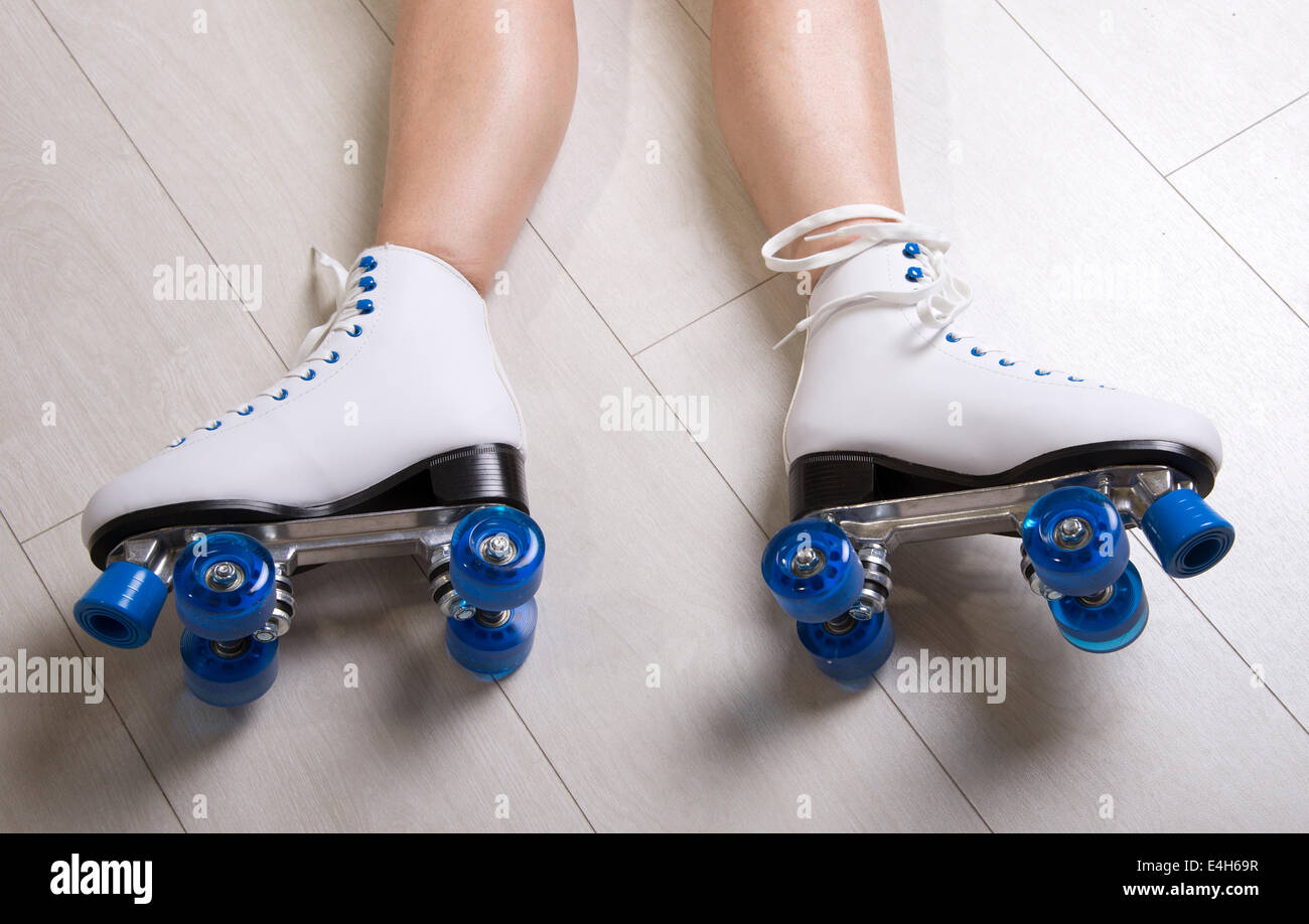 Woman laying on floor wearing blue and white coloured quad roller ...