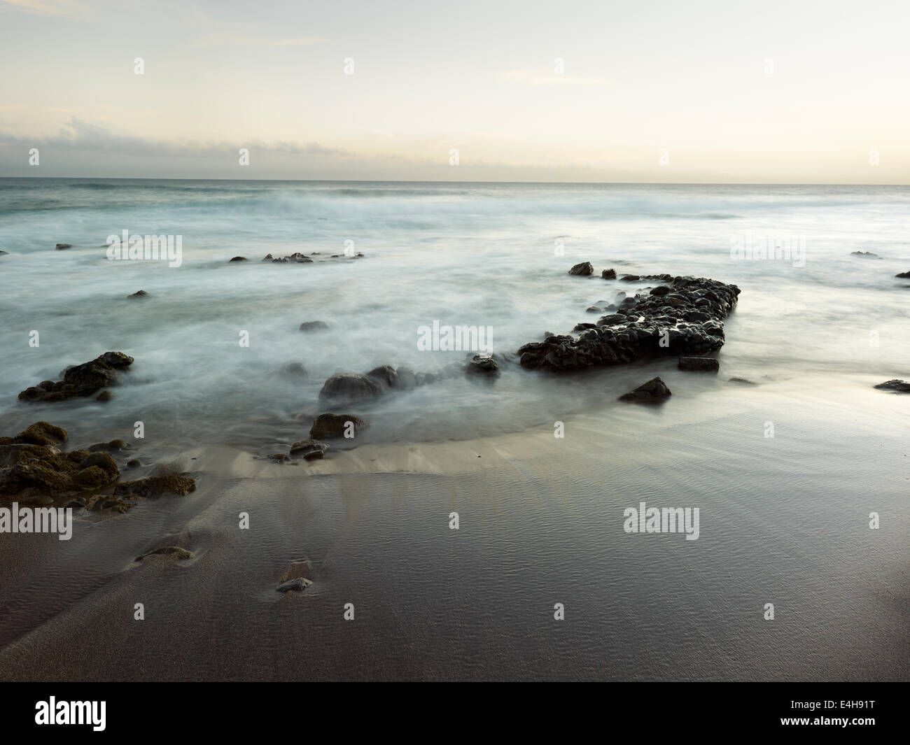 Waves coming in over beach rocks Stock Photo - Alamy