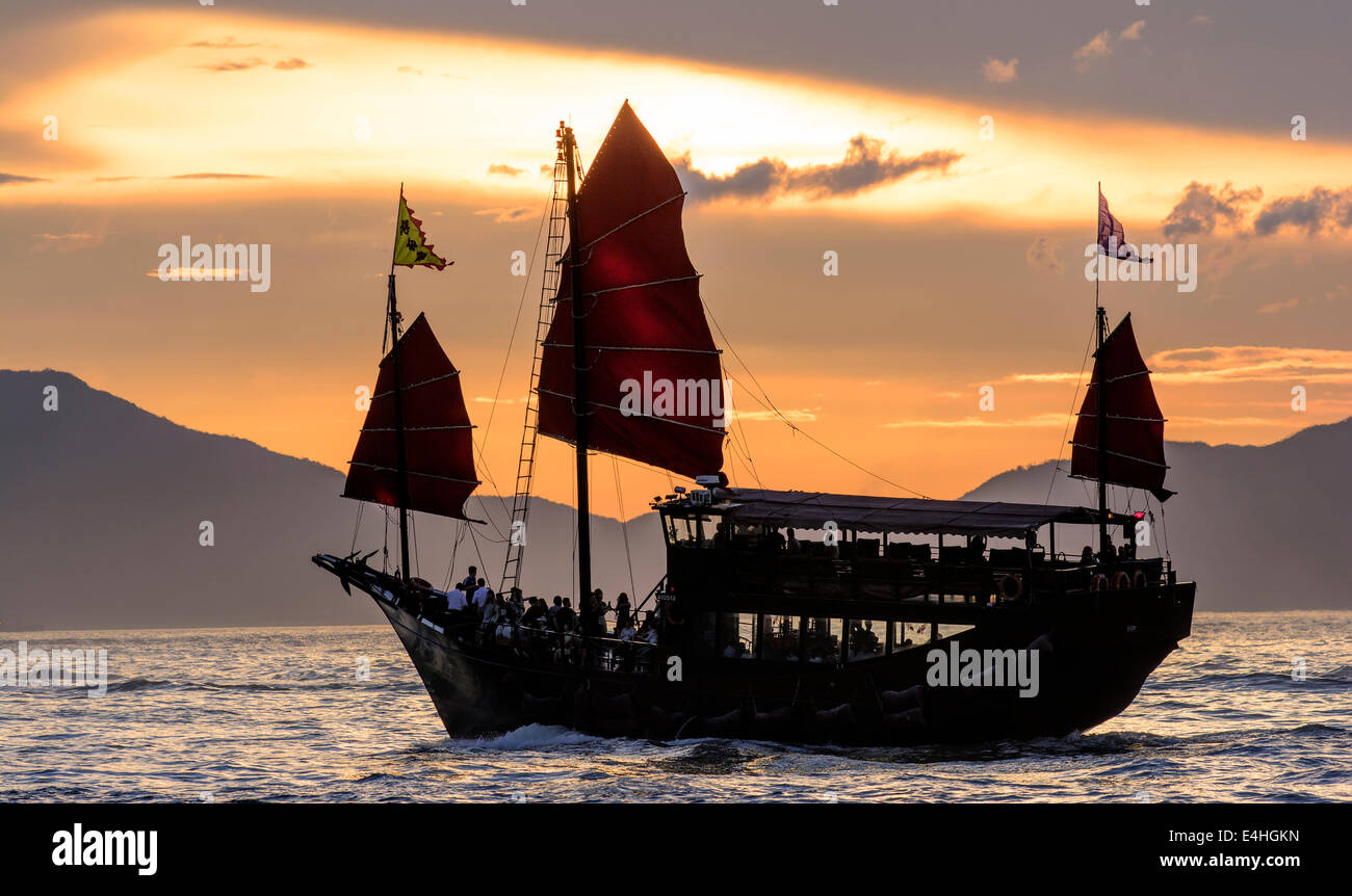A traditional Chinese junk at sunset, Victoria harbor, Hong Kong, China ...