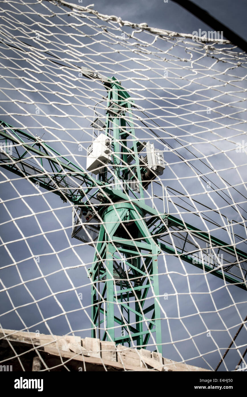 Industrial Crane behind safety net, under construction building ...
