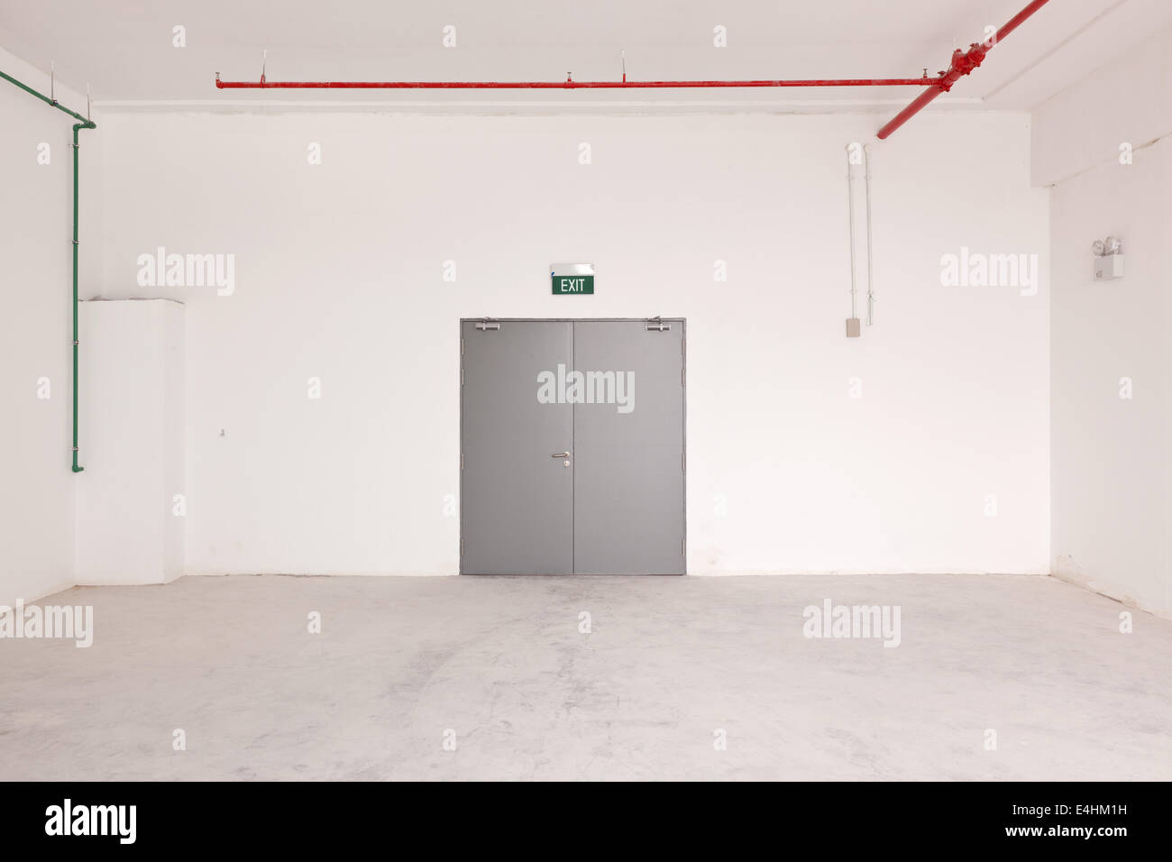 Interior of a bare, empty room with the door and exit sign Stock Photo ...