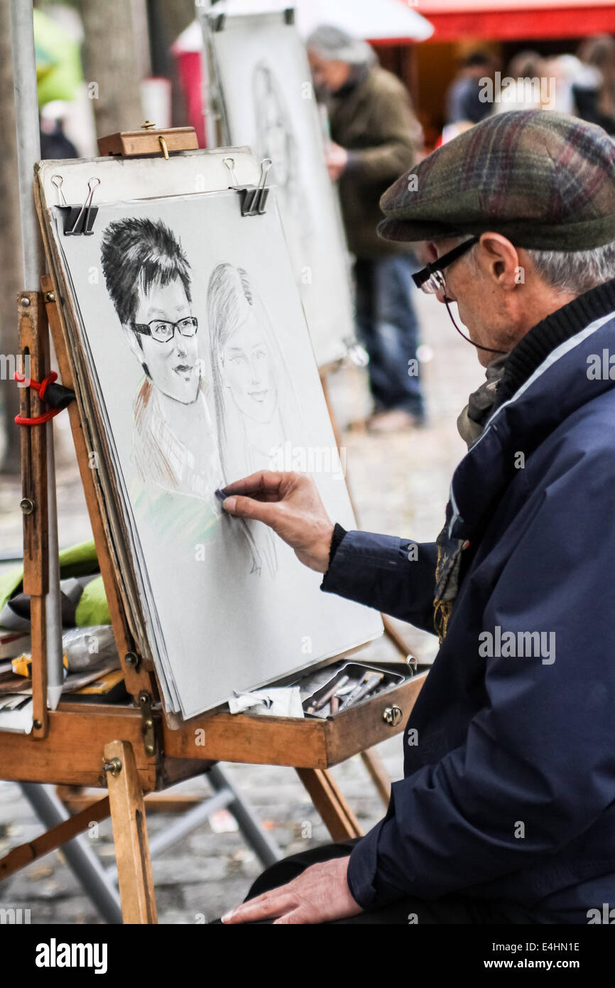 Unidentified man drawing a portrait of the tourist at Place du Tertre ...
