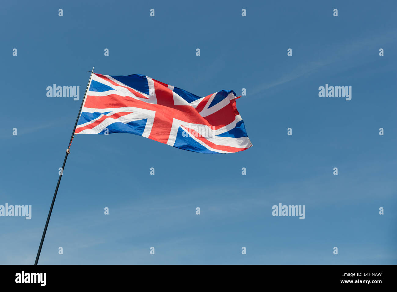 Union Jack Flag flying against a blue sky Stock Photo - Alamy