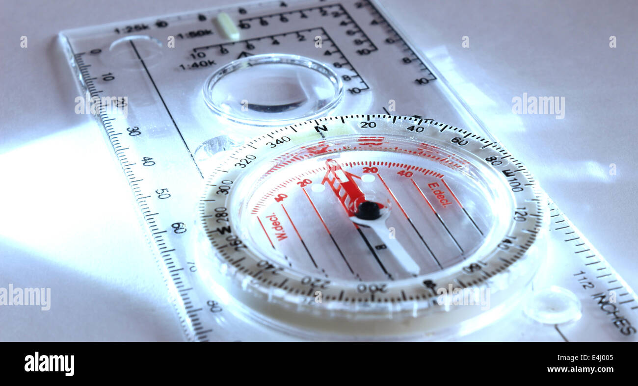 Transparent compass illuminated by torchlight on a white background ...