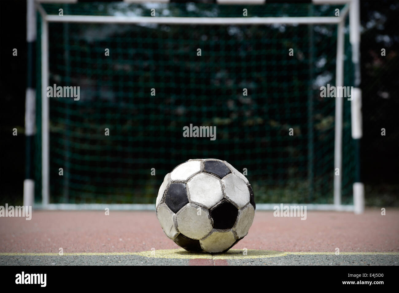 Old and used soccer ball on a cement playing field Stock Photo - Alamy