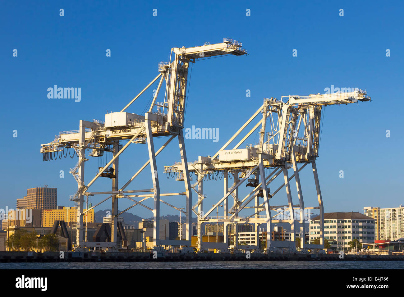 Three giant container cranes looming over the water at the Port of ...