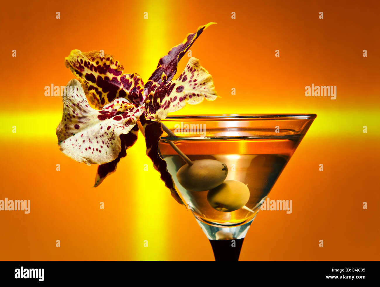 martini , green olives and orchid flower on yellow background Stock ...