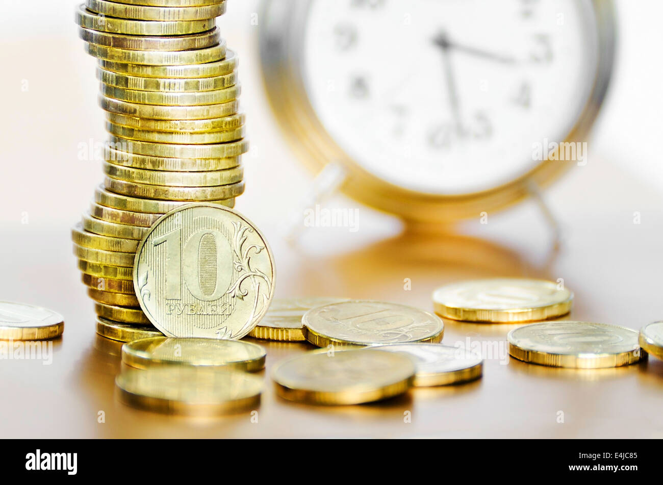 A stack of coins and alarm clock Stock Photo - Alamy