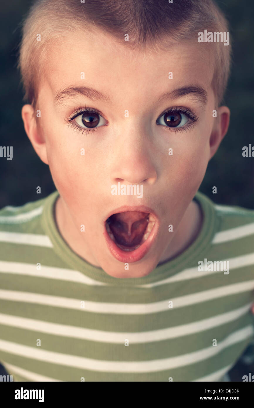 Young boy outdoors with shocked expression Stock Photo - Alamy