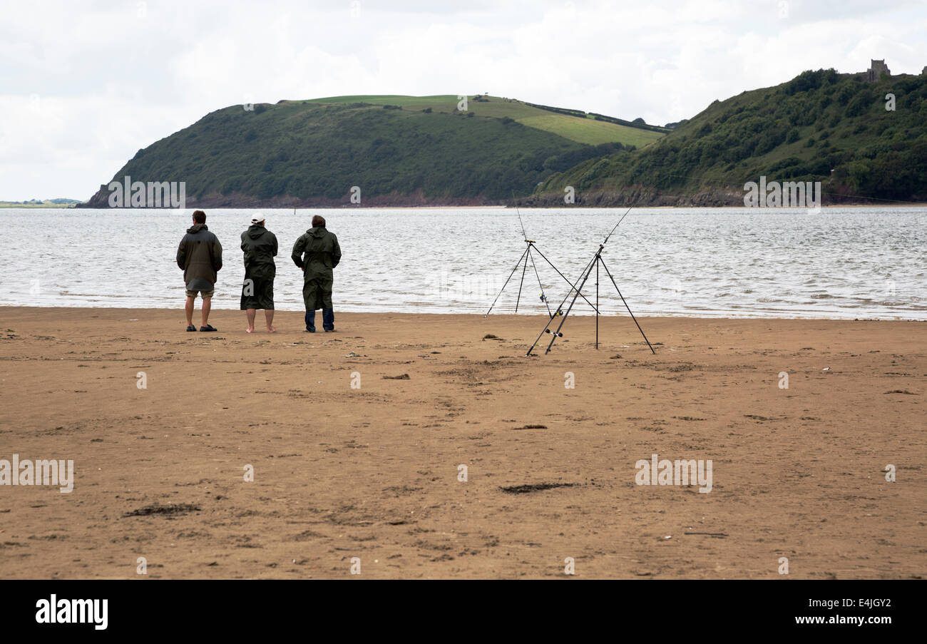 Three fishermen standing on the beach at Ferryside, South Wales ...