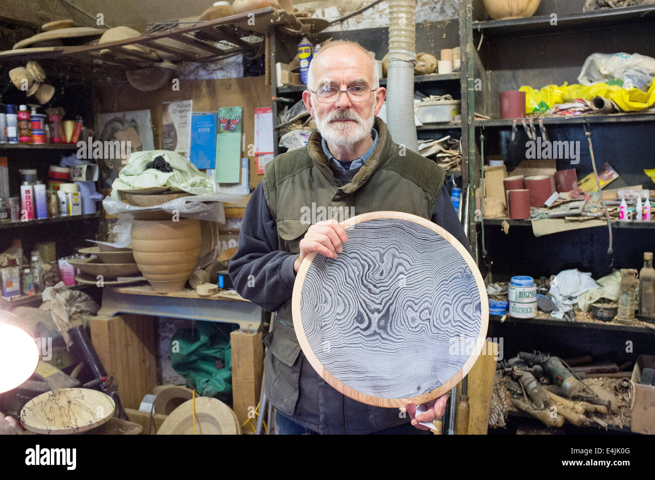 Portrait of Richard Chapman, wood-turner, in his workshop holding a ...