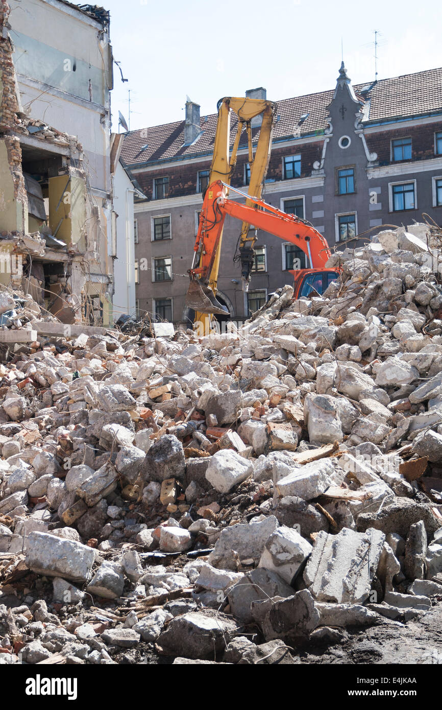 Demolition of an old building with heavy machinery for new construction ...