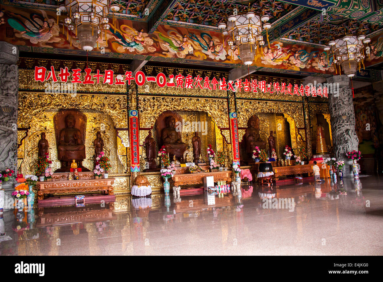 Interior of an ornate Asian temple with statues f deities in recesses ...