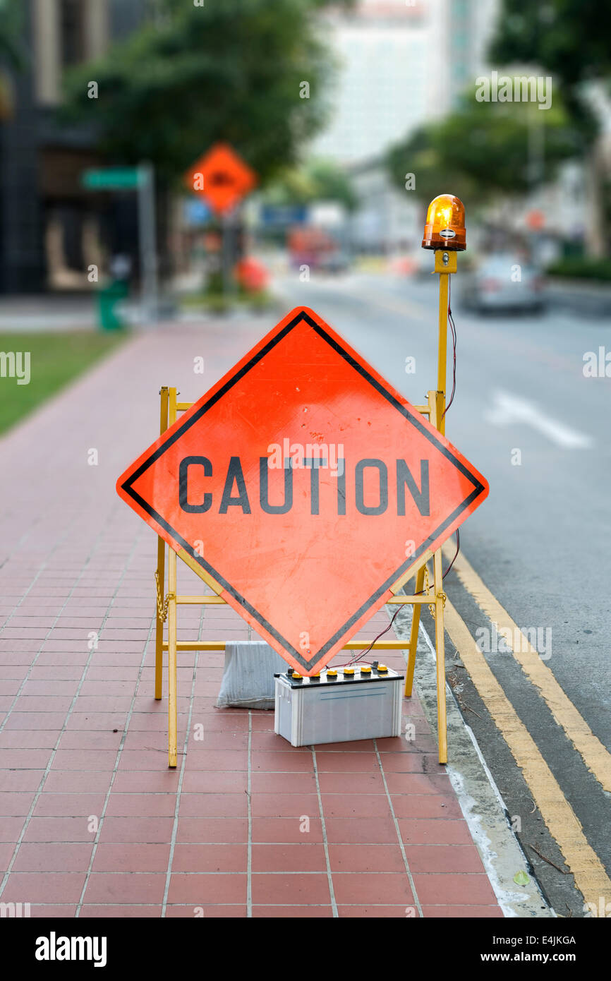 Caution road street sign with defocused street in background Stock ...
