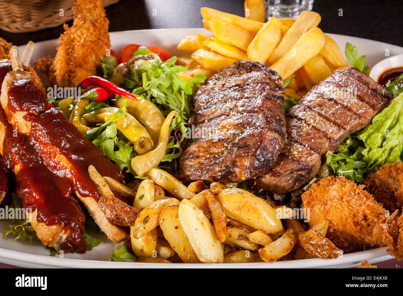 Wholesome platter of mixed meats including grilled steak, crispy ...