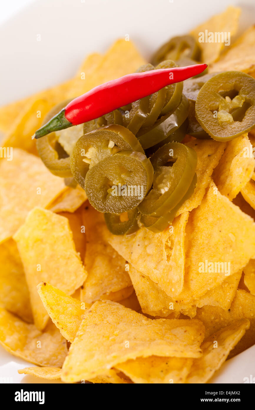 Bowl of crisp golden corn nachos with cheese sauce or dip and olives ...