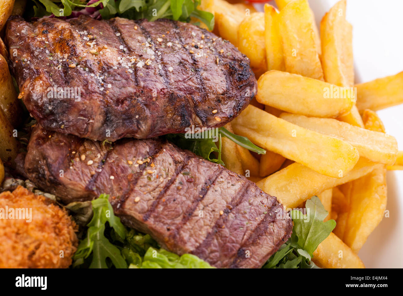 Wholesome platter of mixed meats including grilled steak, crispy ...