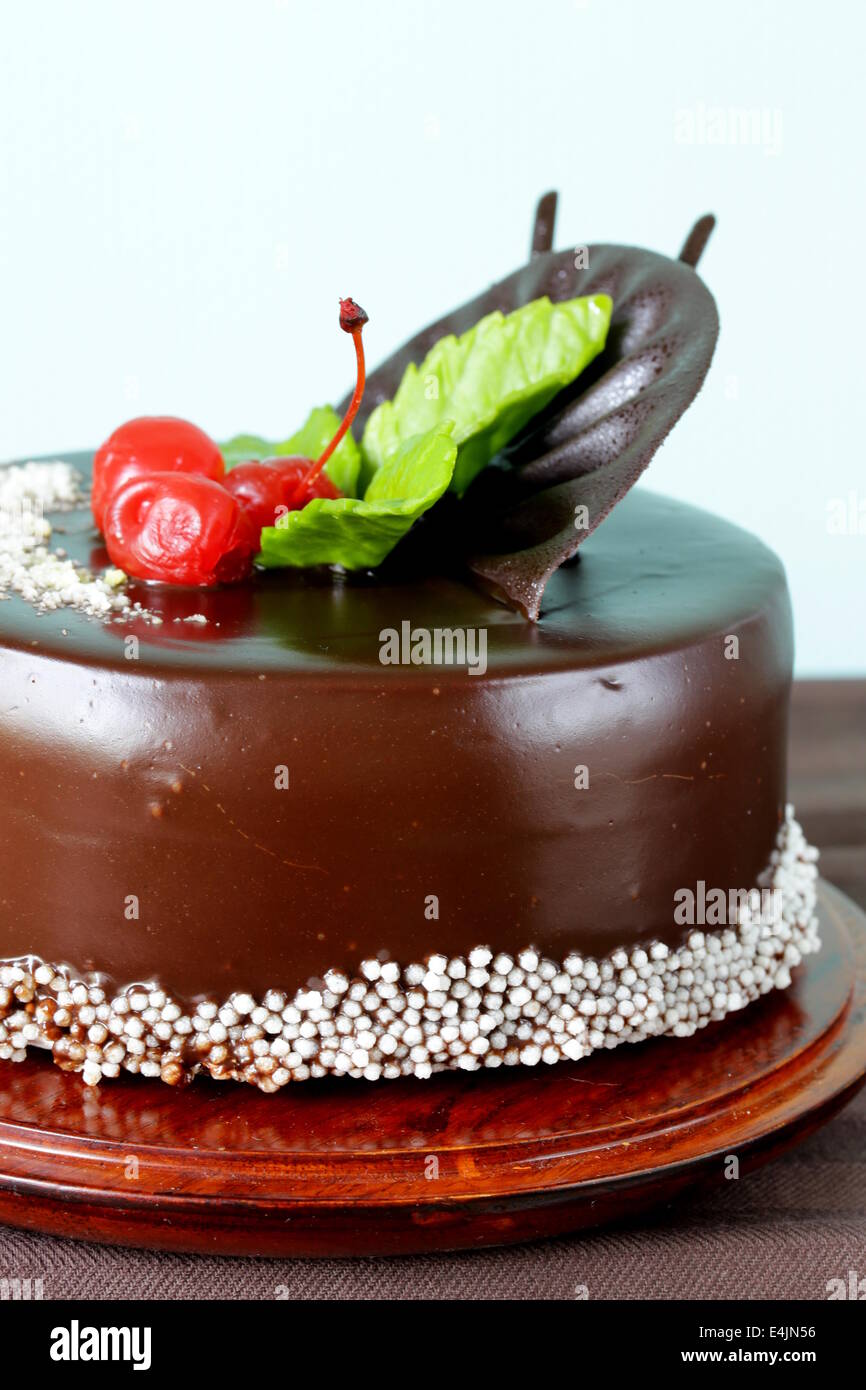 festive beautiful chocolate cake with icing and cherry Stock Photo - Alamy
