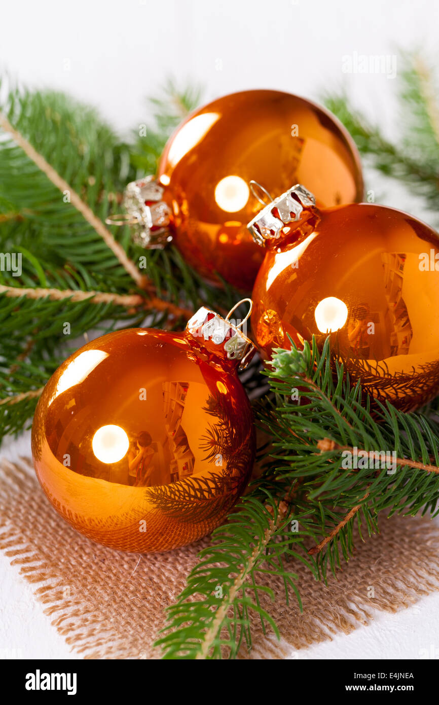 Shiny bright copper colored Christmas balls nestling in a branch of ...