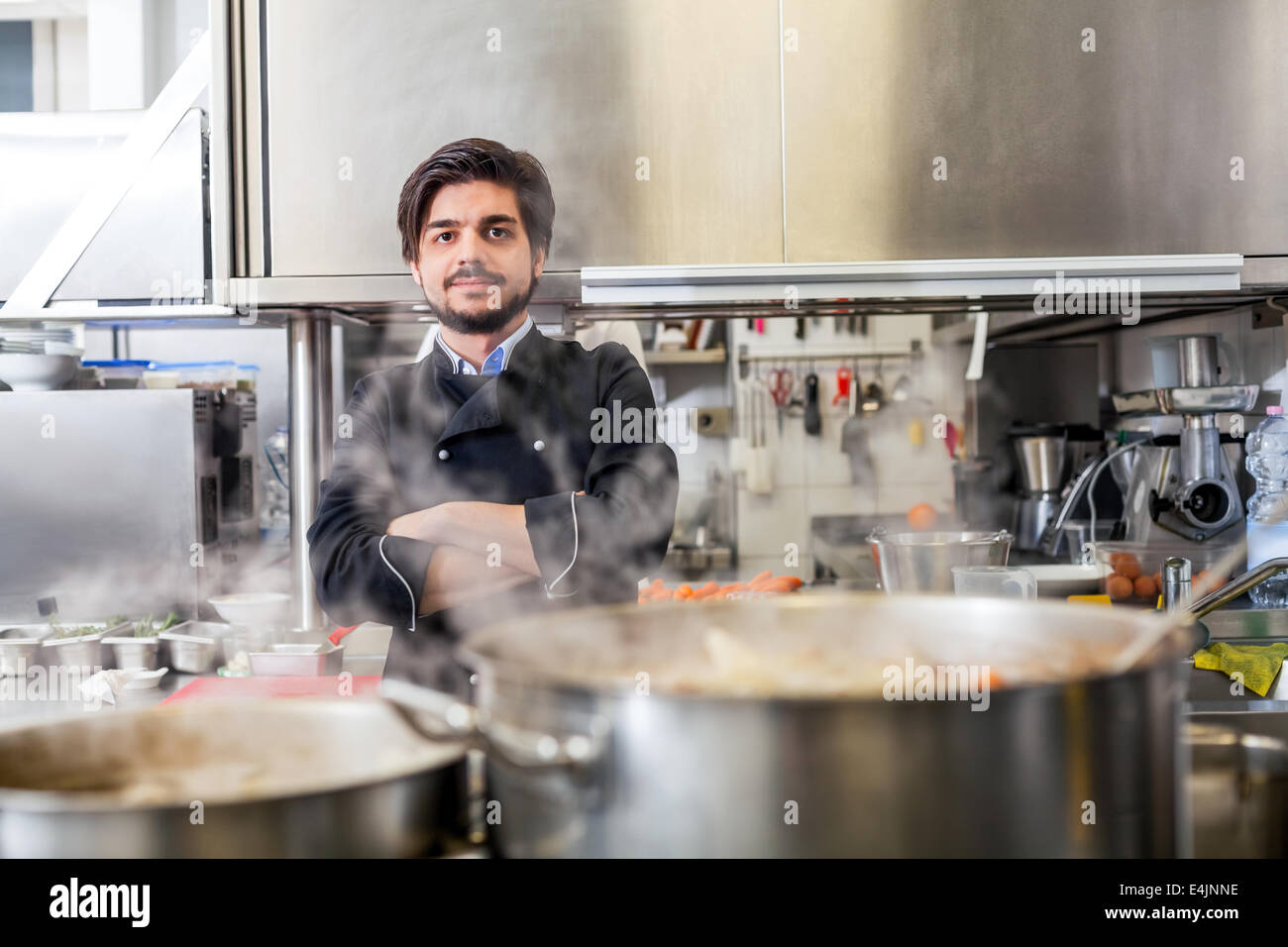 Professional chef in a commercial kitchen cooking a vegetable stir fry ...