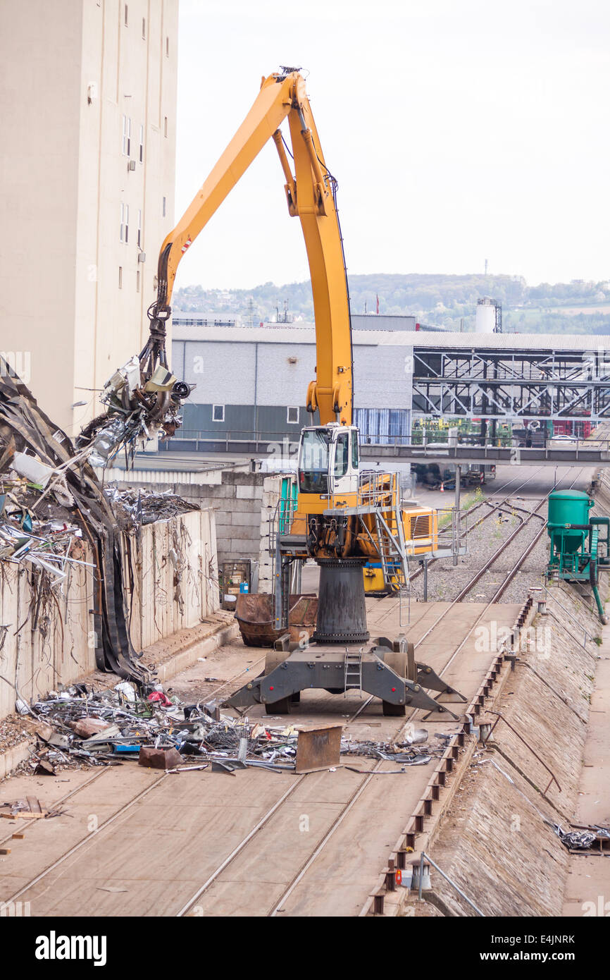 Open barge being loaded or offloaded at a wharf on an urban waterway or ...