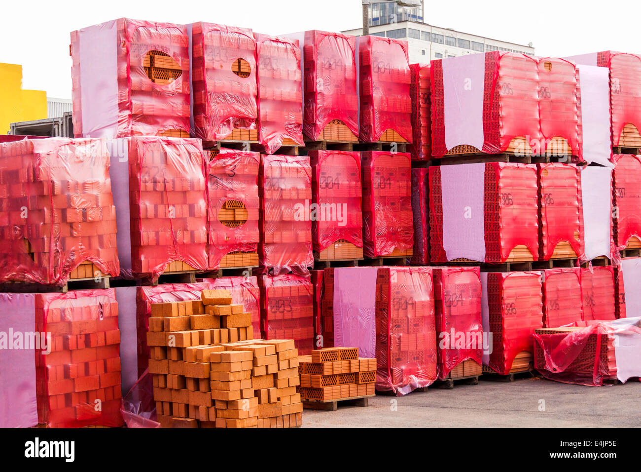 Red clay building bricks stacked on pallets still wrapped in their ...