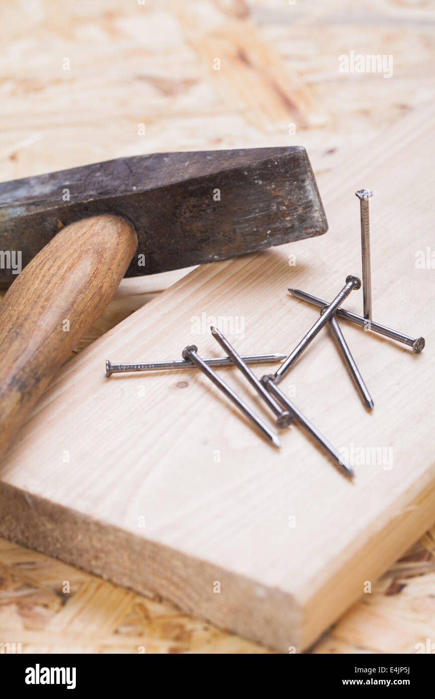 Mallet with nails and planks of new wood of varying thicknesses in a ...