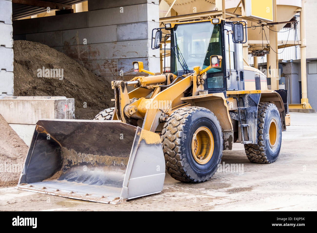 Parked pay loader near pile of dirt at a construction site Stock Photo ...
