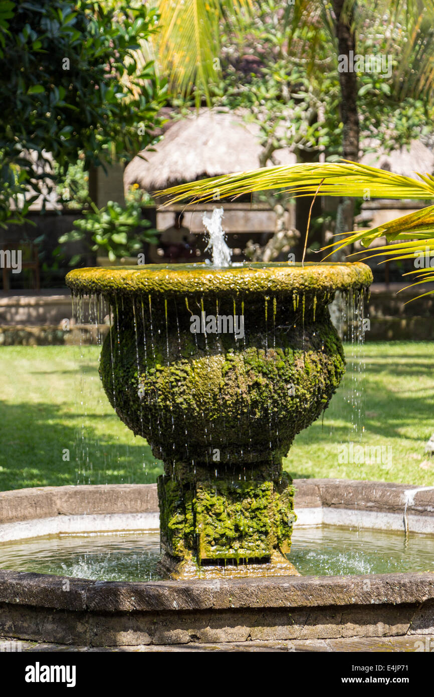 Ornamental fountain in a shallow pond in a landscaped garden outside a ...