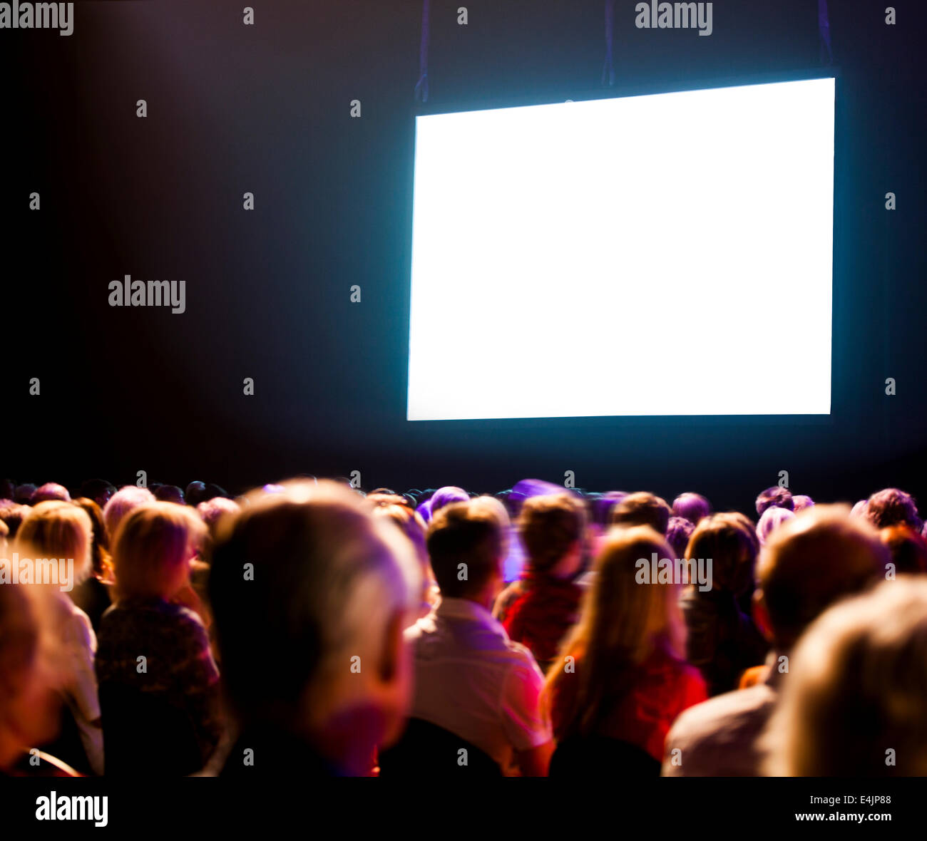 Crowd audience in dark looking at bright screen Stock Photo - Alamy