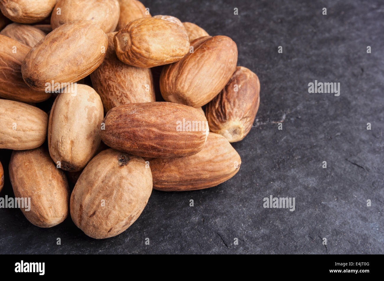 Nutmeg on dark stone background Stock Photo - Alamy