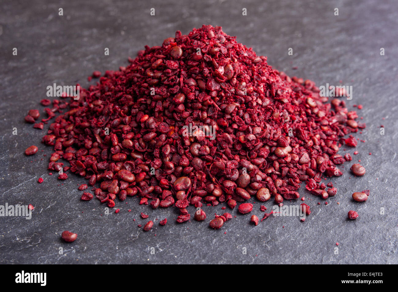 Heap ground sumach on dark stone background Stock Photo - Alamy